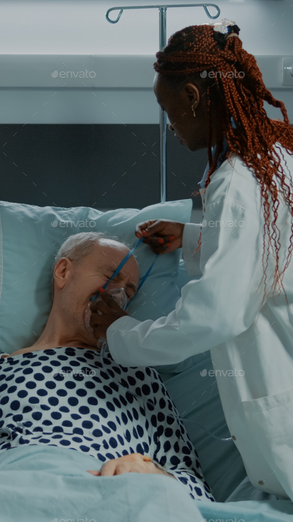 Multi ethnic nurse and doctor helping sick patient Stock Photo by DC_Studio