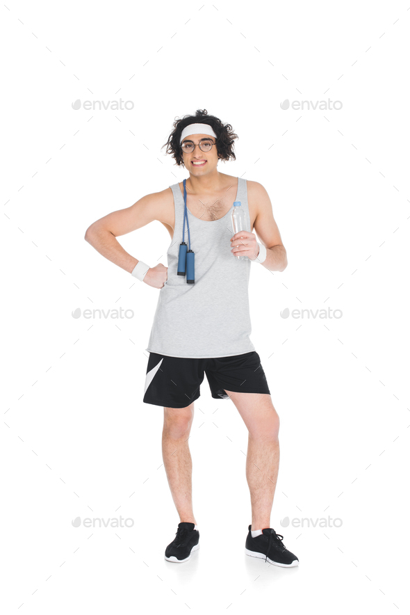 Smiling thin sportsman standing with jump rope on shoulder isolated on ...