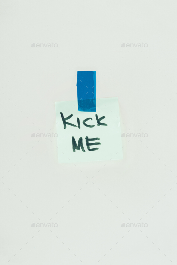 close up view of note with kick me lettering and sticky tape isolated ...