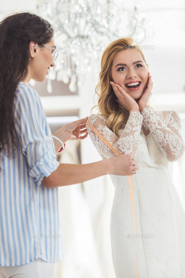 Bride in lace dress and tailor in wedding atelier Stock Photo by ...