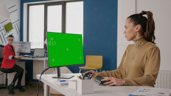 Business woman looking at green screen on computer Stock Photo by DC_Studio