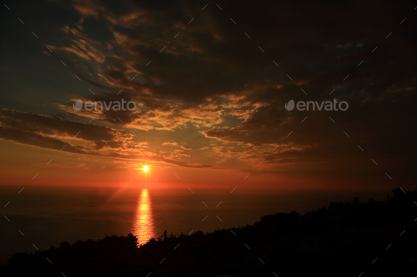 Deep orange sun with reflection on surface of the sea Stock Photo by rawf8