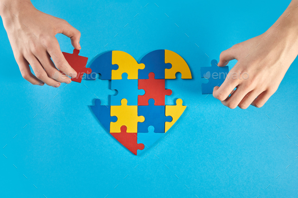 Autistic boy hands holding jigsaw puzzle heart shape. World Autism ...