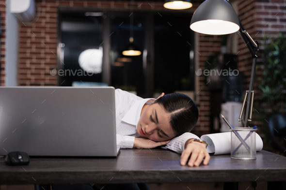 Fatigued business company employee sleeping on desk because of overtime ...