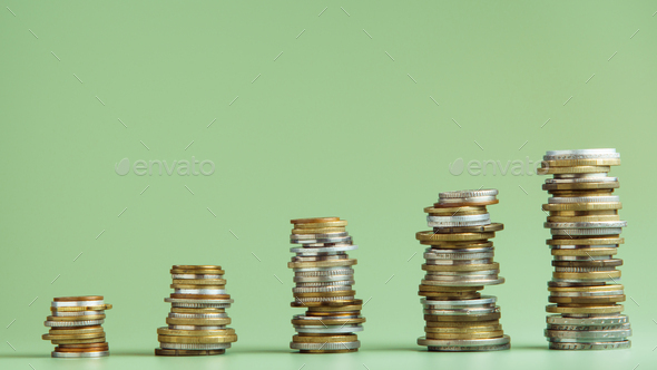 Side view of five stacks towers of different coins arranged in growing ...