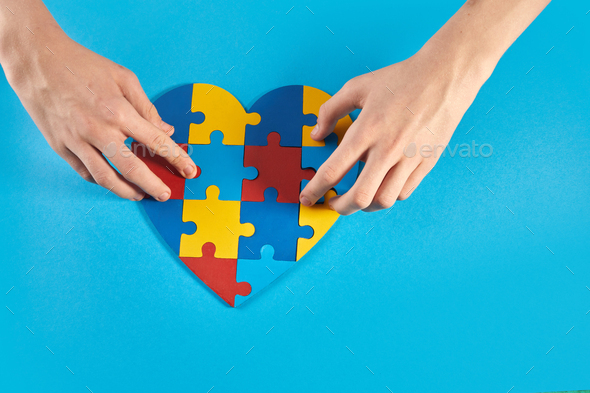 Autistic boy hands holding jigsaw puzzle heart shape. World Autism ...