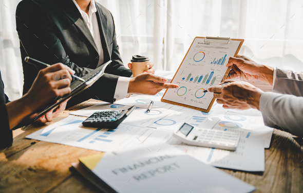 Young colleagues discuss business and analytical price charts using ...