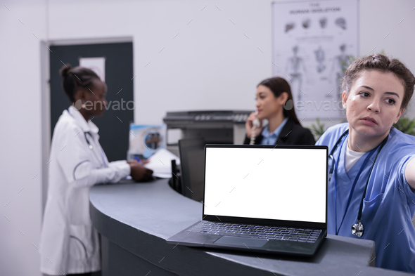 Laptop computer with white isolated screen standing on hospital counter ...
