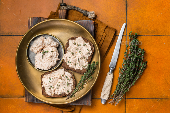 Toasts with Cod liver Spread pate on a plate. Orange background. Top ...