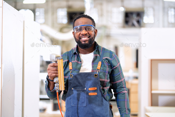 In work place carpenter man working using pneumatic nail gun stand ...