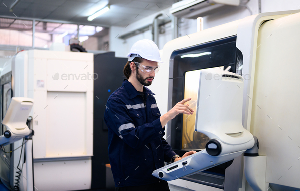 Engineer mechanician operating and controlling CNC machine Stock Photo ...