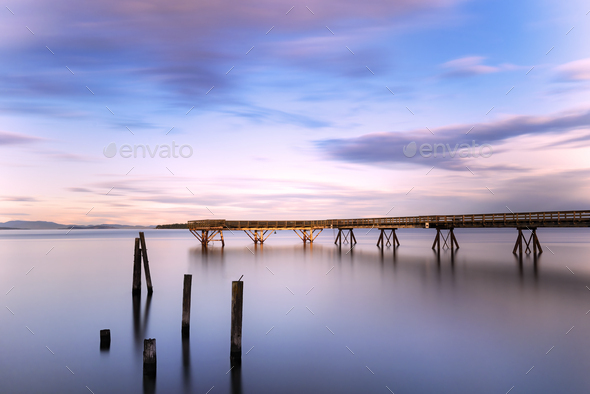 Long pier stretching out at a misty ocean at sunset Stock Photo by ...