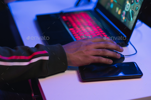 Closeup of a male gamer doing a live video game streaming on a laptop ...