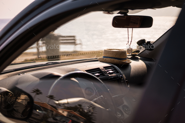 View inside a car with a hat on the dashboard Stock Photo by wirestock