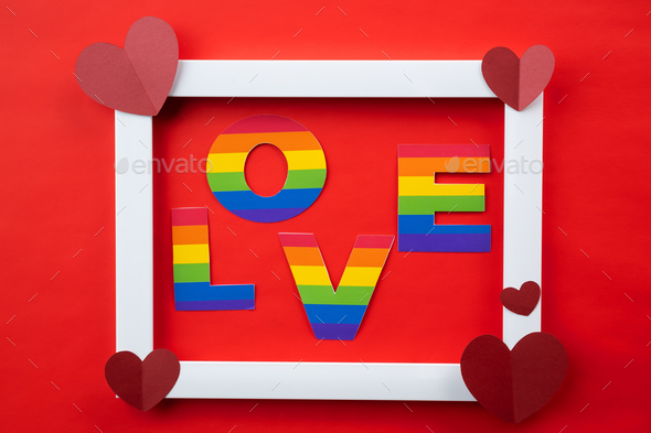 LGBT love paper letters on a frame with hearts against red background ...