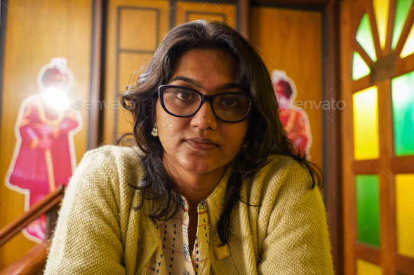 Shallow focus shot of an Indian female with glasses looking at the ...
