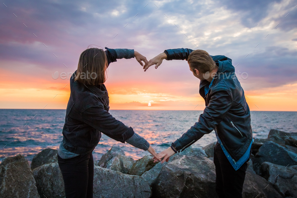 Mesmerizing shot of a loving couple making a heart shape with their ...