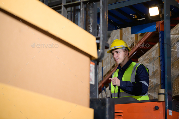 Worker in auto parts warehouse use a forklift to work to bring the box ...