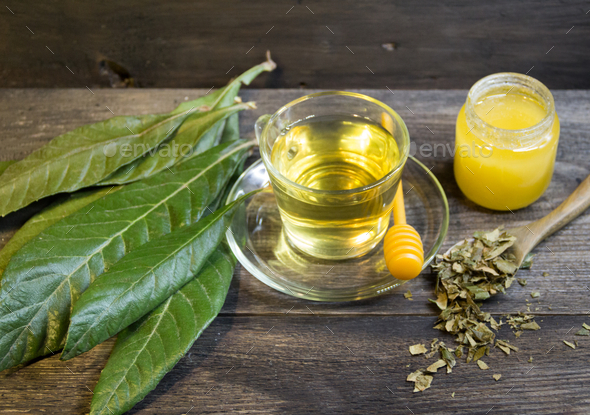 medicinal infusion of loquat leaves with honey, on rustic wooden ...