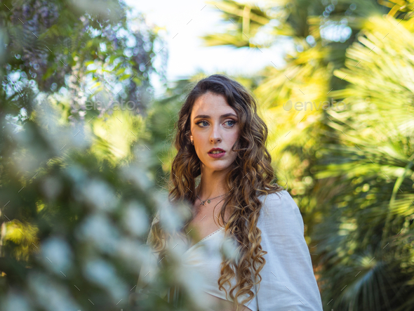 Beautiful young Spanish lady wearing a stylish white blouse is posing ...
