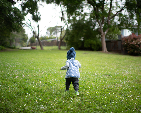 Back view of a little boy running in the green park Stock Photo by ...