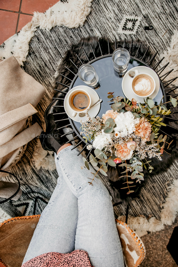 Top-view aesthetic shot of a woman's legs by the coffee table with ...