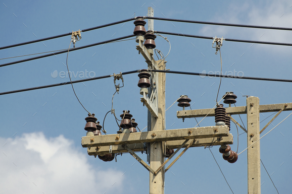 Electrical insulators set with transmission lines on background of sky ...
