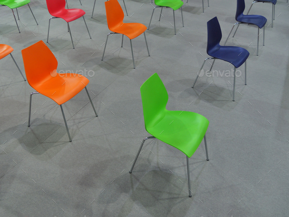 High angle shot of colorful chairs arranged with distance between them ...