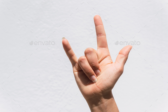 Closeup of the ILY hand sign against a white wall background Stock ...