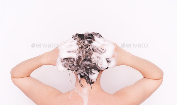Lady washing her hair with shampoo against white background Stock Photo ...