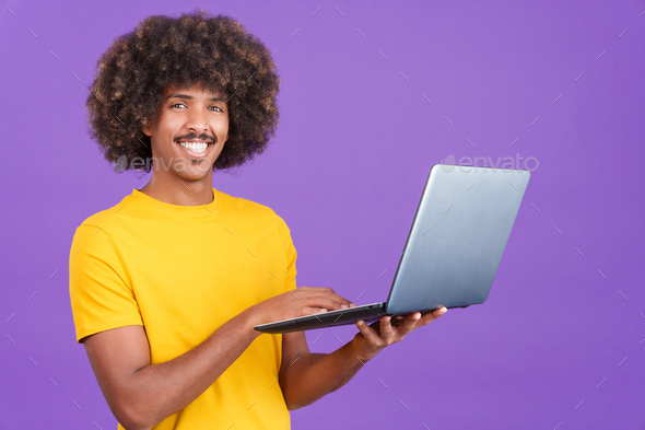 Smiley african man standing and using a laptop Stock Photo by ivanmorenosl
