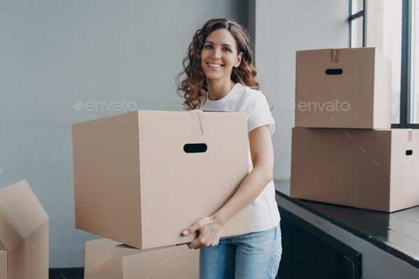 Happy girl carrying box. New home and independence concept. Real estate ...