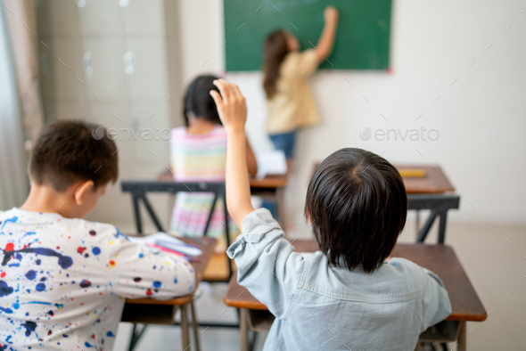 Back of boys sit in back of class during their friend one girl writing ...