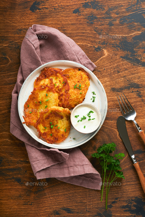 Potato pancakes. Fried homemade potato pancakes or latkes with cream ...