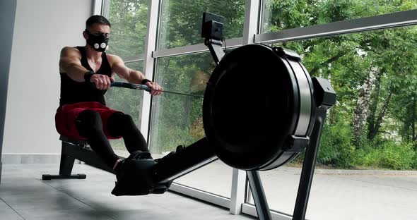 Strong Muscular Male Working on Indoor Rower Simulator. Cross Fitness ...