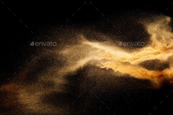 Sand explosion isolated on black background.Freeze motion of sandy dust ...
