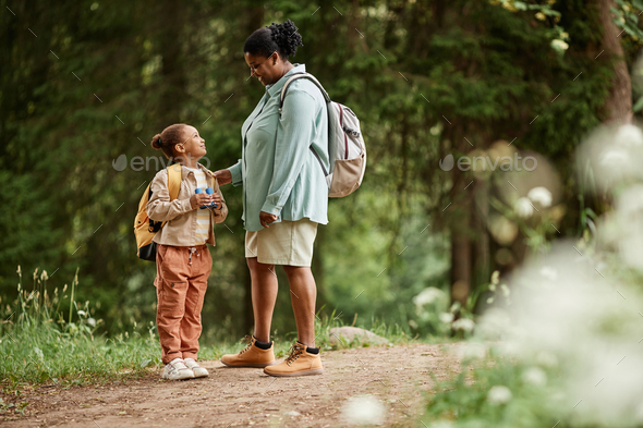 Caring black mother and daughter hiking together in beautiful nature trail Stock Photo by ...