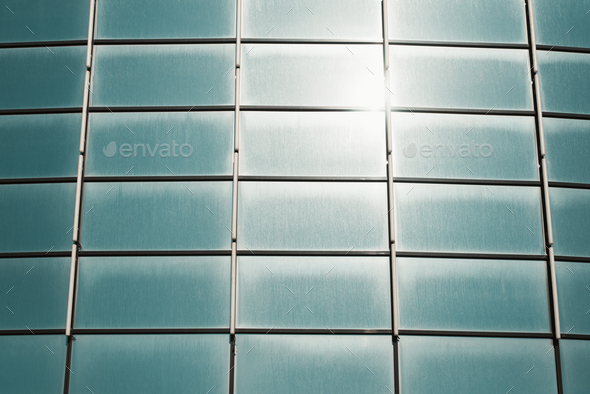 Close-up blue glass windows of commercial building exterior, front view ...