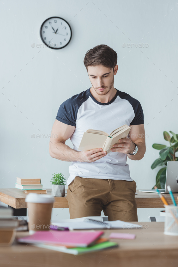 male student studying with book in room with copybooks Stock Photo by ...