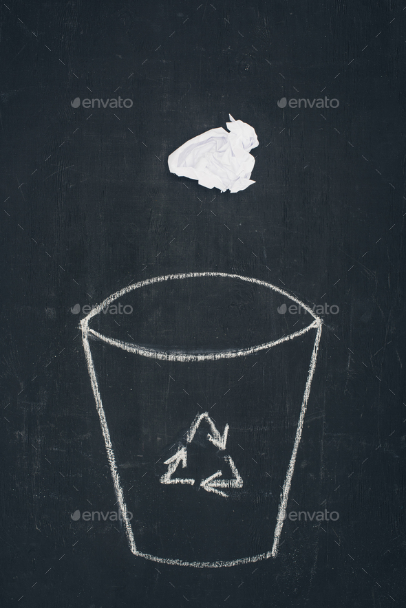 crumpled paper falling into drawn trash bin with recycle sign on ...