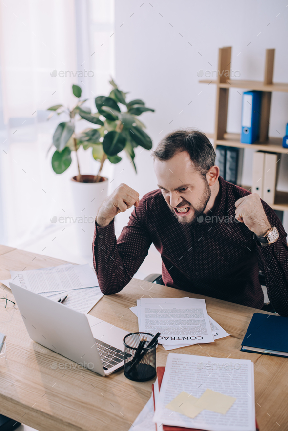 angry and overworked businessman at workplace with laptop in office ...