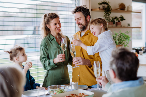Happy family toasting before the Easter dinner. Stock Photo by halfpoint