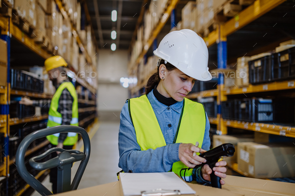 Warehouse female worker checking up stuff in a warehouse. Stock Photo ...