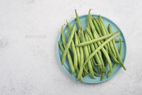 Green string beans on a textured background, empty space for text ...