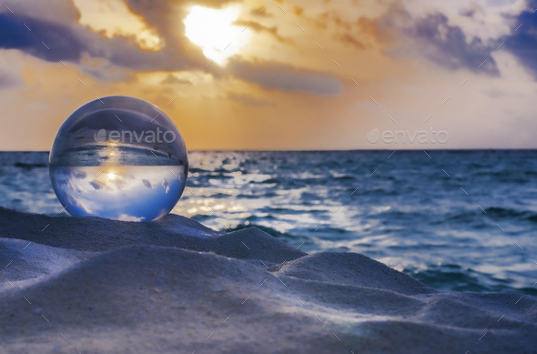Reflection of the sky and the ocean on a crystal ball on the sand Stock ...