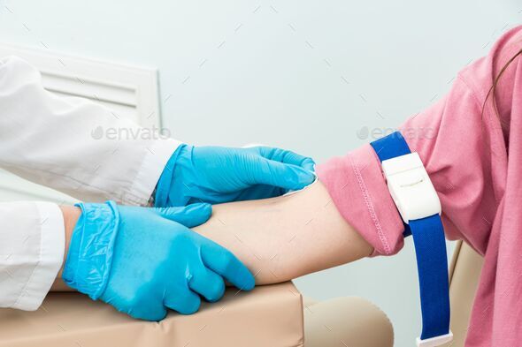 Nurse's gloved hands prepare patient's right hand for blood sampling ...