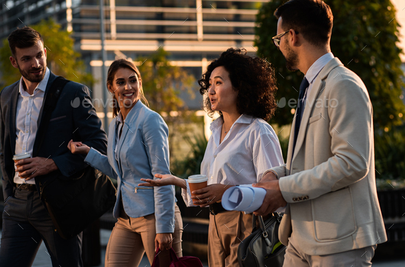 Group of business people walking outside in front of office buildings ...