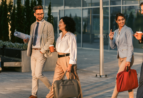 Group of business people walking outside in front of office buildings ...
