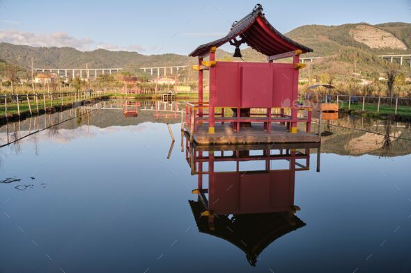 Japanese temple in the lake with a reflection in water, a sunlit ...