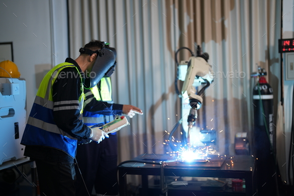 Robotic Arm engineer check on equipment in its with software of an ...